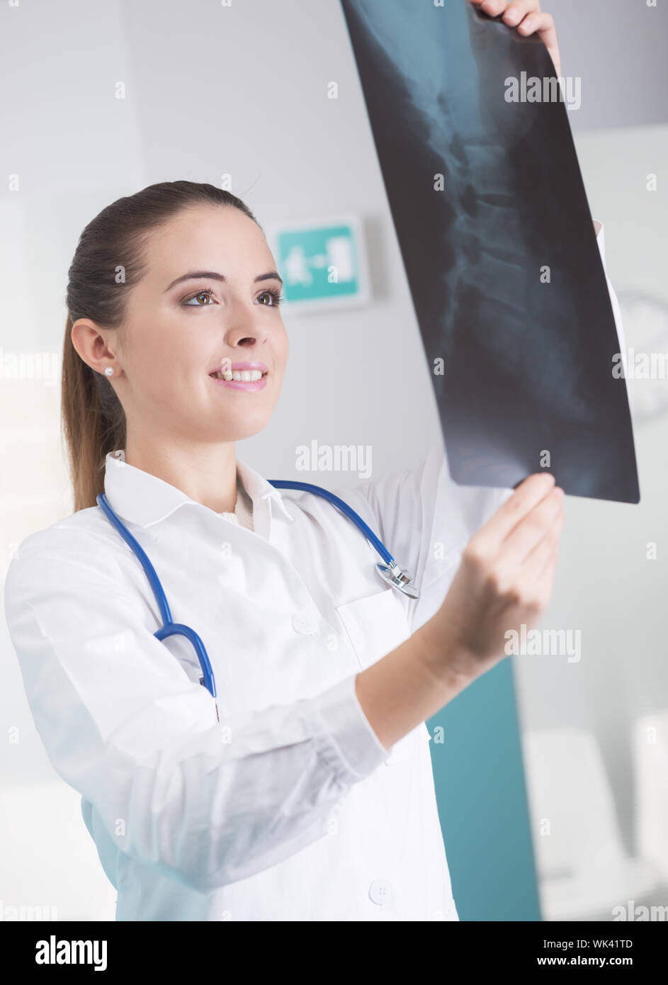 Female doctor checking xray image and smiling Stock Photo - Alamy
