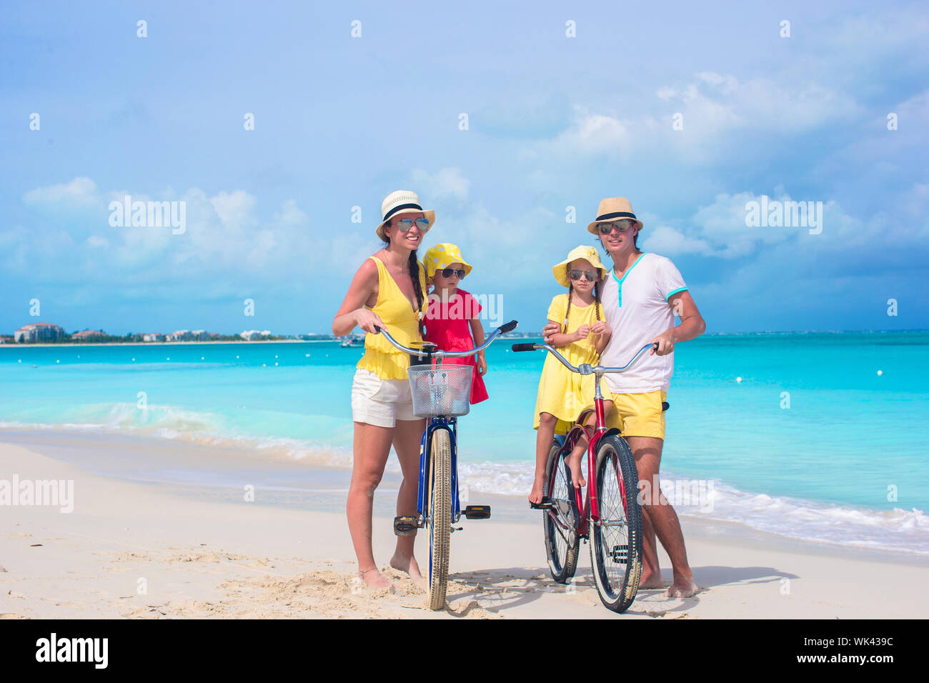 Young parents and kids riding bicycles on a tropical sand beach Stock ...