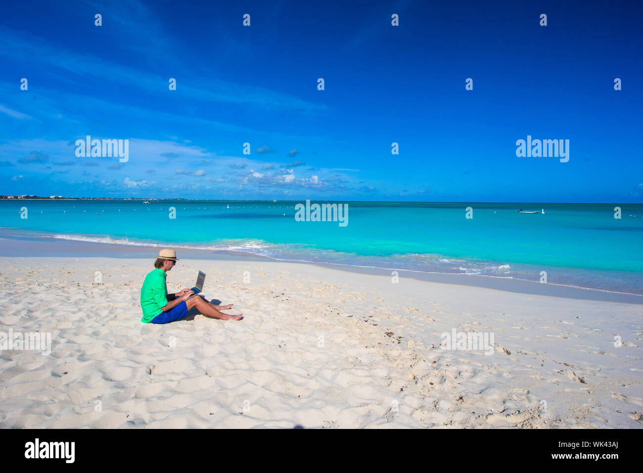 Young man using laptop on the beach Stock Photo - Alamy