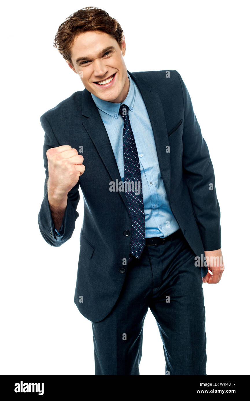 Excited young businessman clenching fist Stock Photo - Alamy