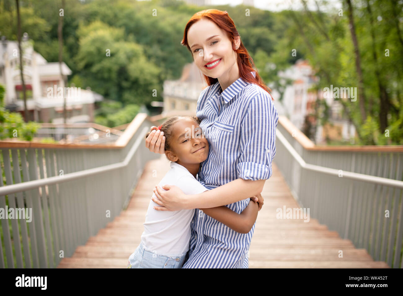 Red-haired woman feeling emotional after adoption cute girl Stock Photo ...