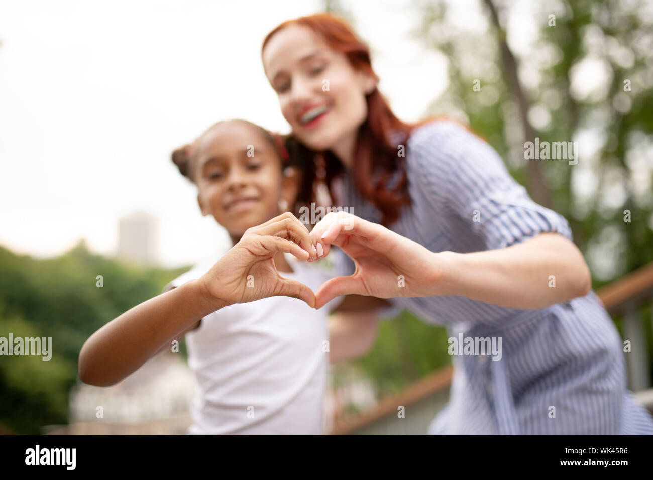 Daughter and mother making heart with their hands Stock Photo - Alamy