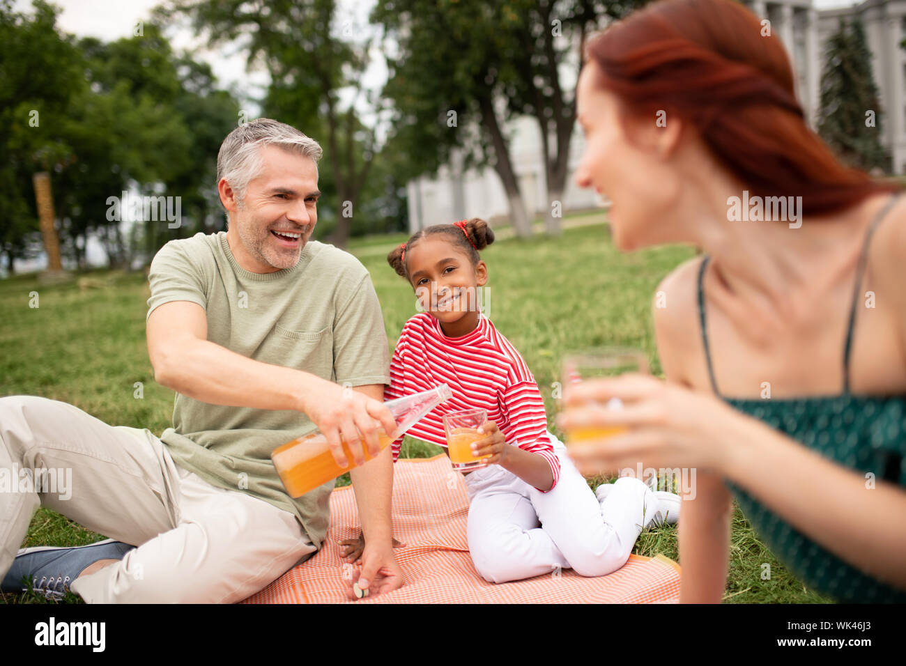 Caring father pouring juice in glass for his beautiful daughter Stock ...