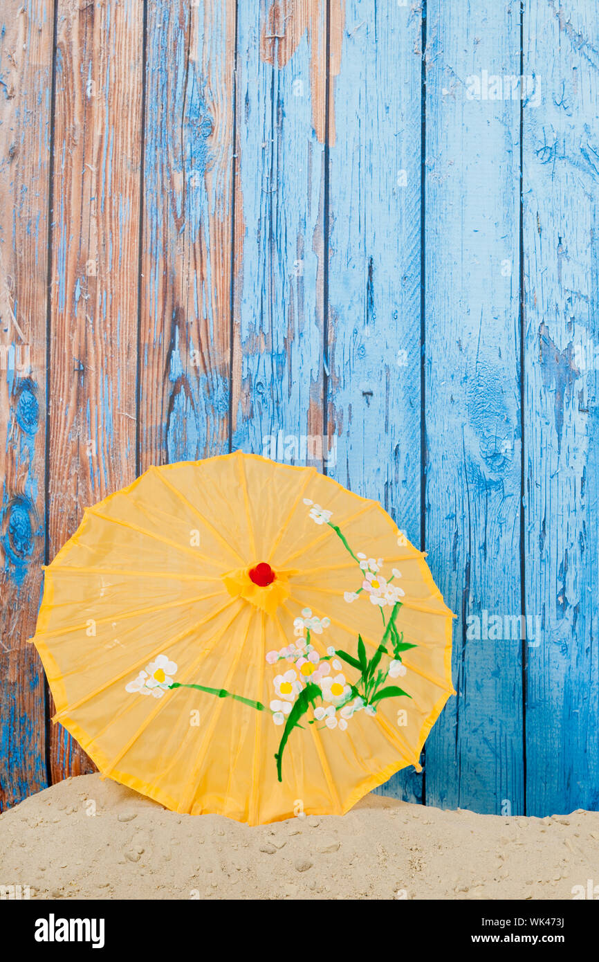 Sand and yellow parasol at the beach with wooden blue vintage ...