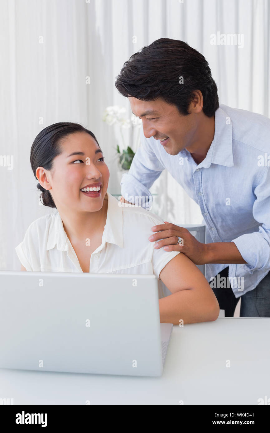 Happy Couple Using Laptop Together At Home In The Living Room Stock