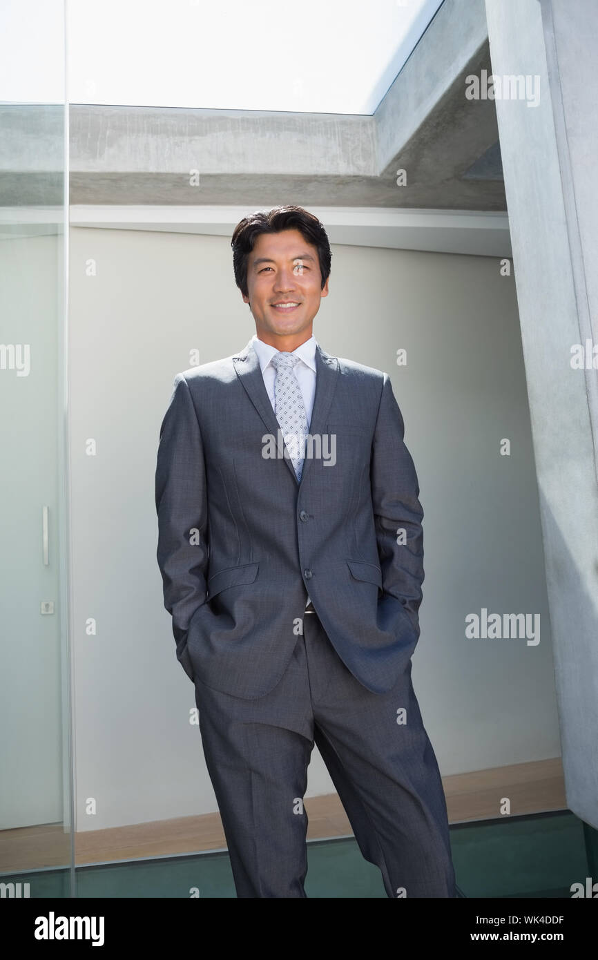 Confident estate agent standing at front door outside a house Stock ...