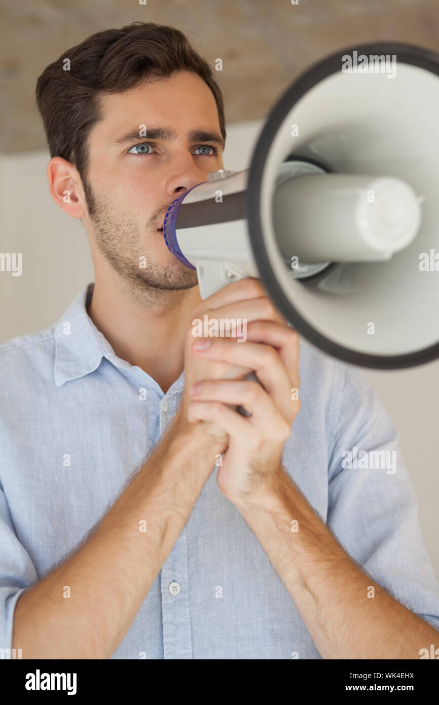 Casual businessman talking through megaphone in his office Stock Photo ...