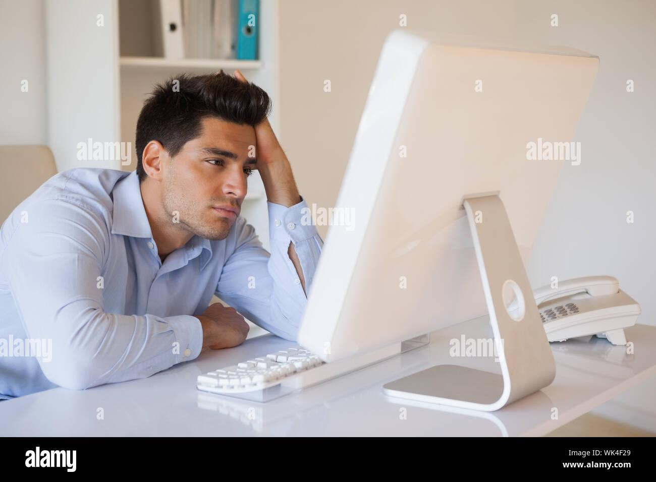 Casual businessman slumped at his desk in his office Stock Photo - Alamy