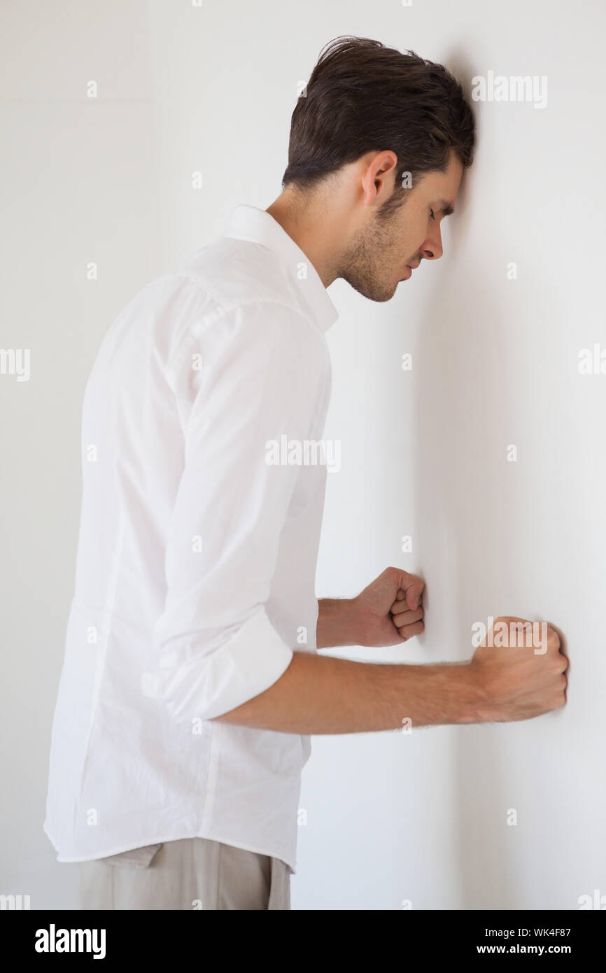 Casual stresed businessman leaning against the wall in his office Stock ...
