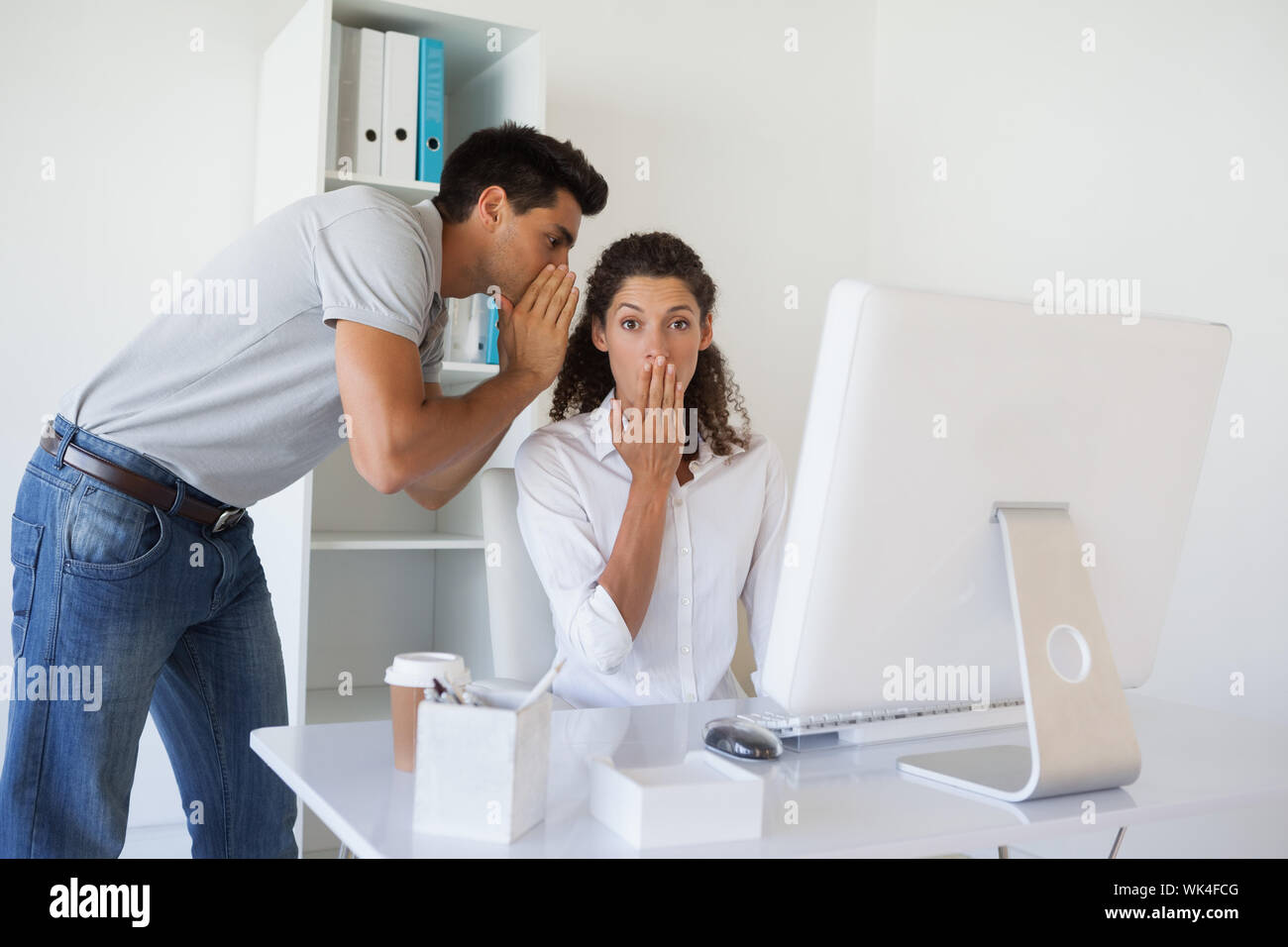 Casual business team gossiping at desk in the office Stock Photo - Alamy