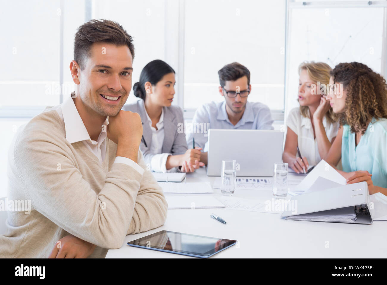 Casual businessman smiling at camera during meeting in the office Stock ...