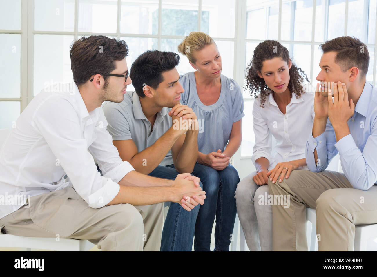 Group therapy in session sitting in a circle in a bright room Stock ...