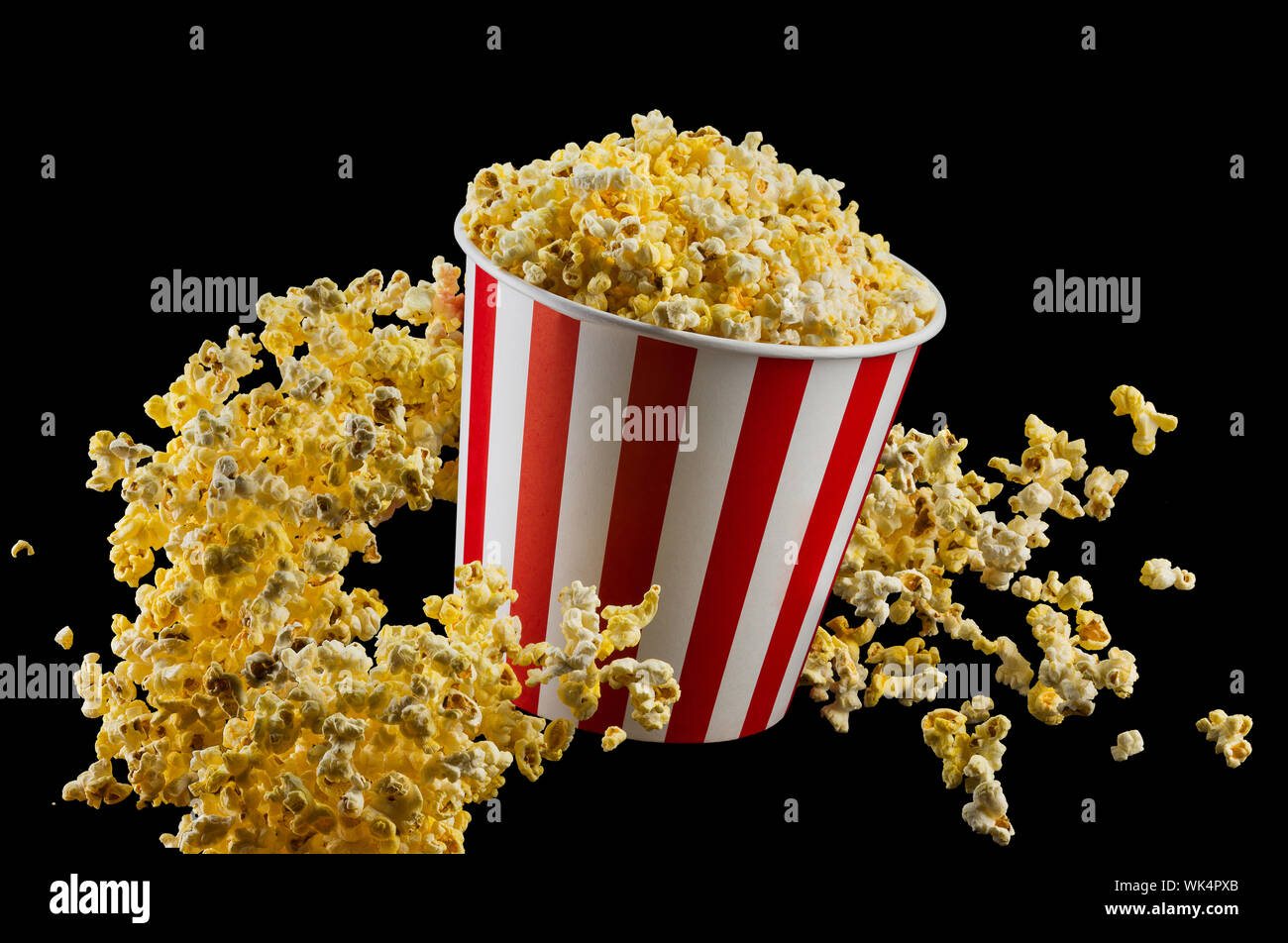 Flying popcorn from striped bucket isolated on black background Stock ...