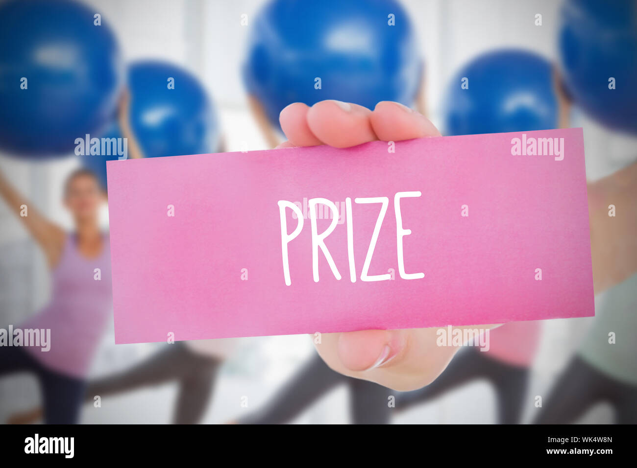 Woman holding pink card saying prize against fitness class in gym Stock ...