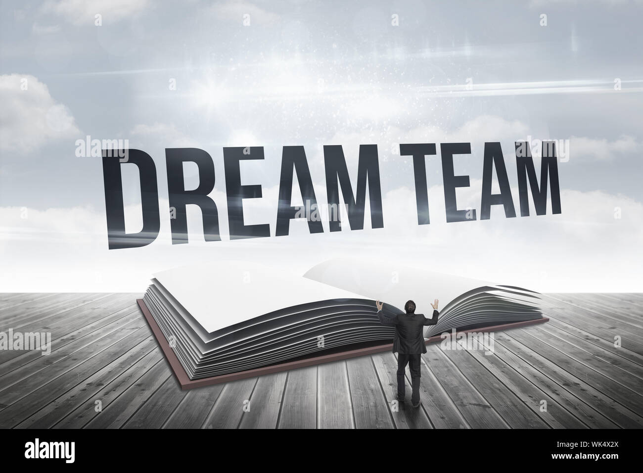 The word dream team and gesturing businessman against open book against ...