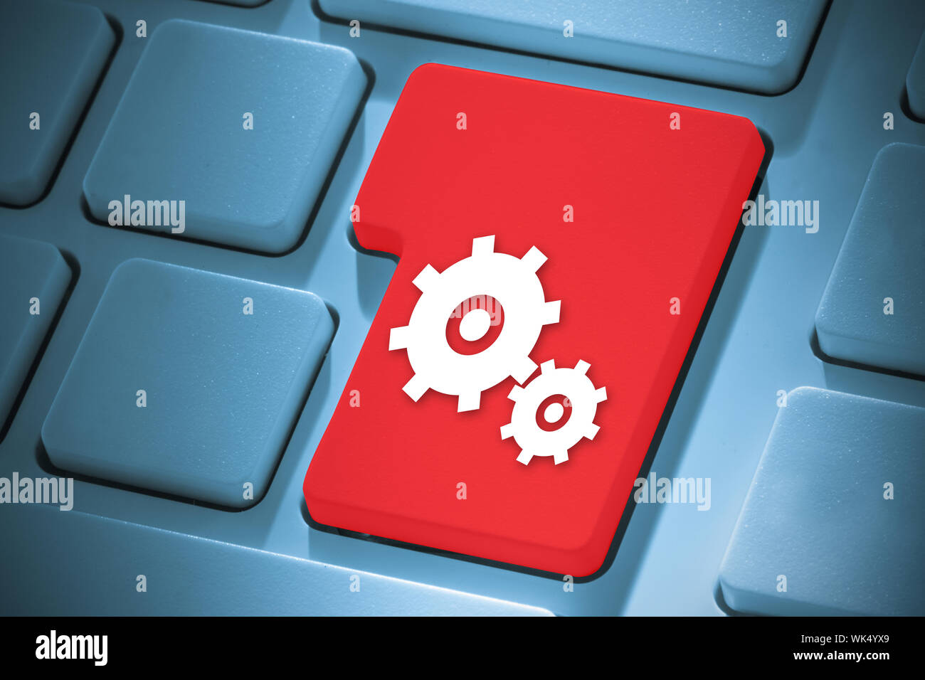 Cog and wheel against red enter key on keyboard Stock Photo - Alamy