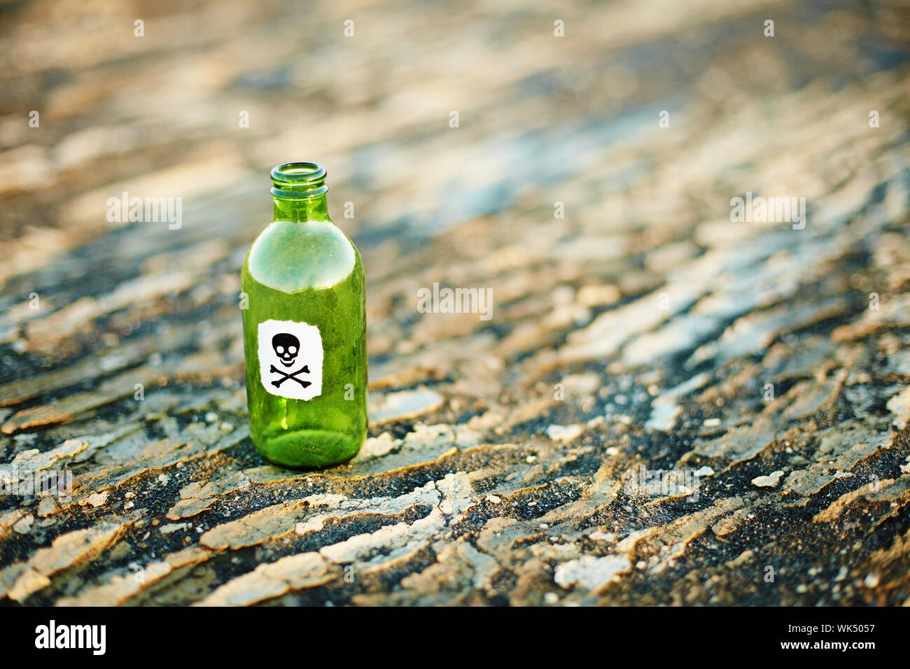 Green glass bottle from a poison on the ground Stock Photo - Alamy