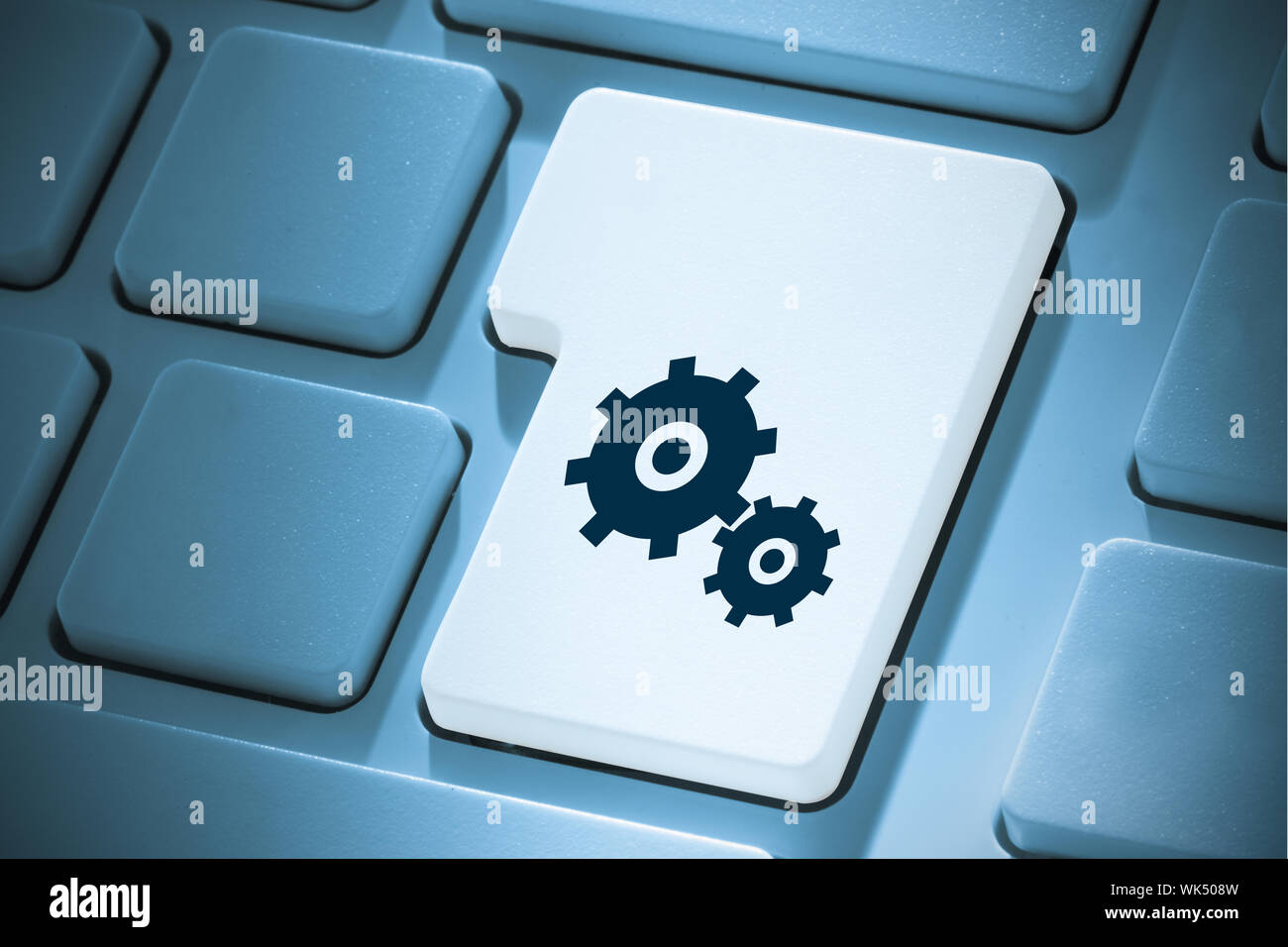 Cog and wheel against white enter key on keyboard Stock Photo - Alamy