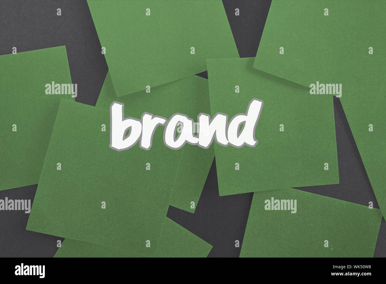 The word brand against green paper strewn over black Stock Photo - Alamy