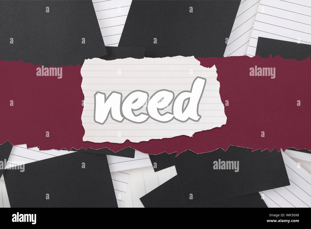 The word need against black paper strewn over notepad Stock Photo - Alamy