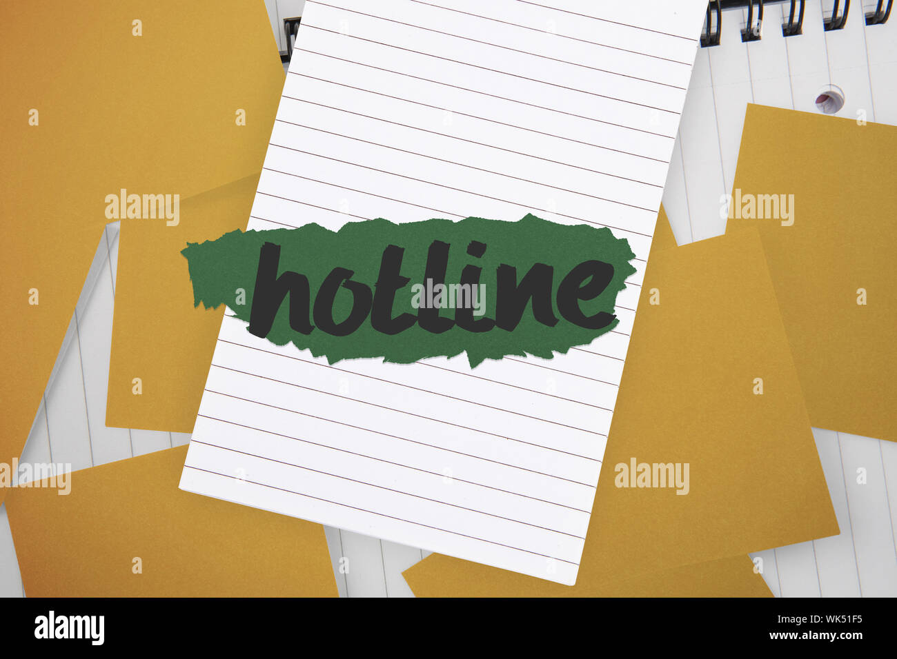 The word hotline against yellow paper strewn over notepad Stock Photo ...