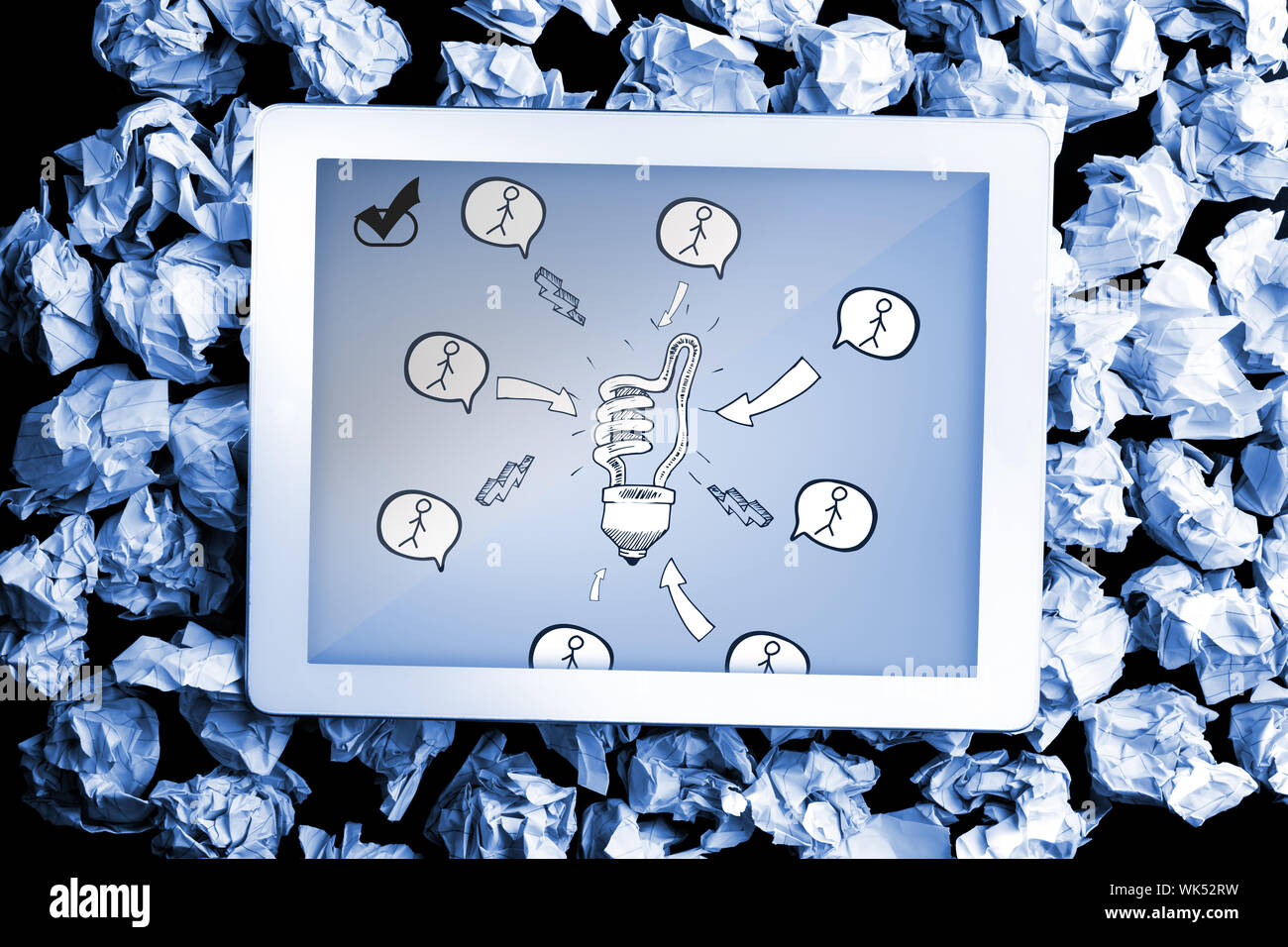 Light bulb doodle with stick figures on digital tablet on crumpled ...