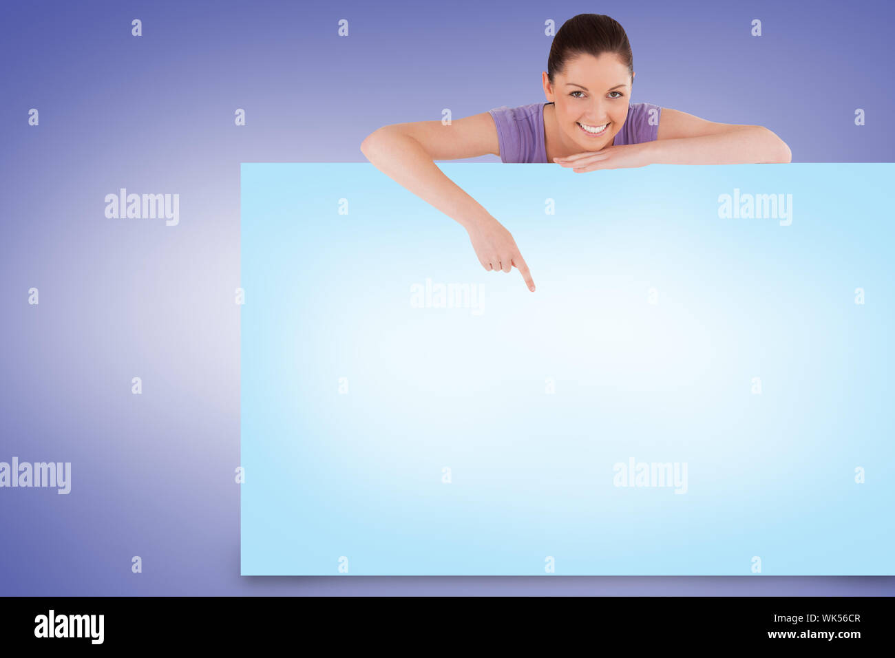 Composite image of pretty brunette showing blue card Stock Photo - Alamy