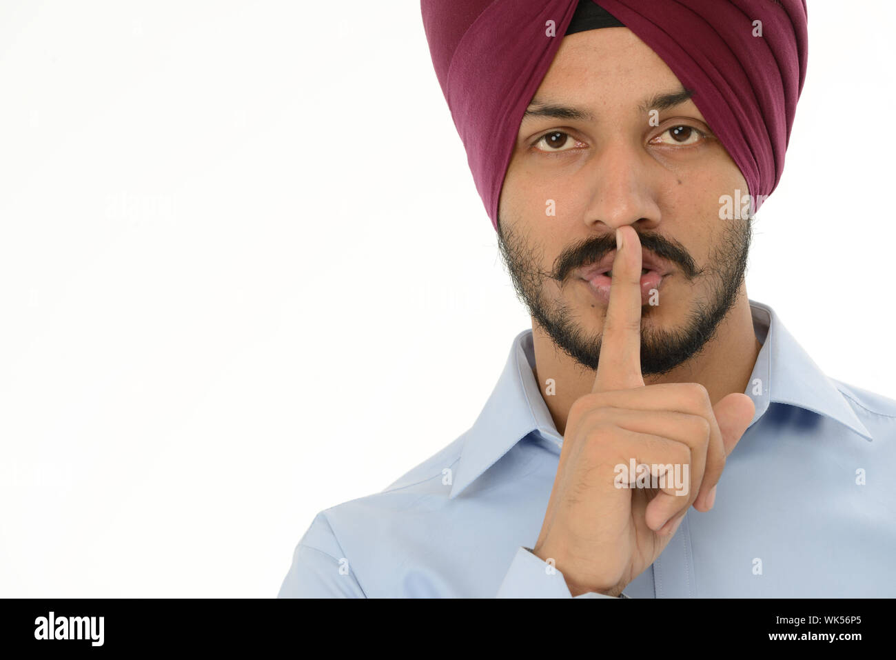 Portrait of an Indian businessman with finger on lips Stock Photo - Alamy