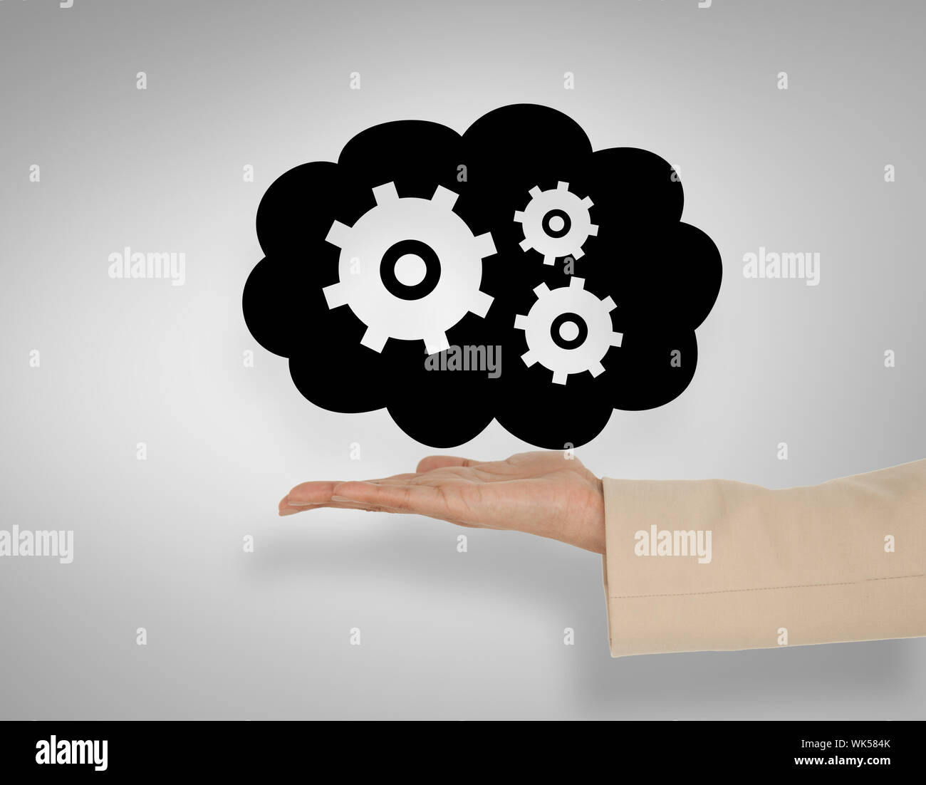 Female hand presenting cogs and wheels against grey vignette Stock ...