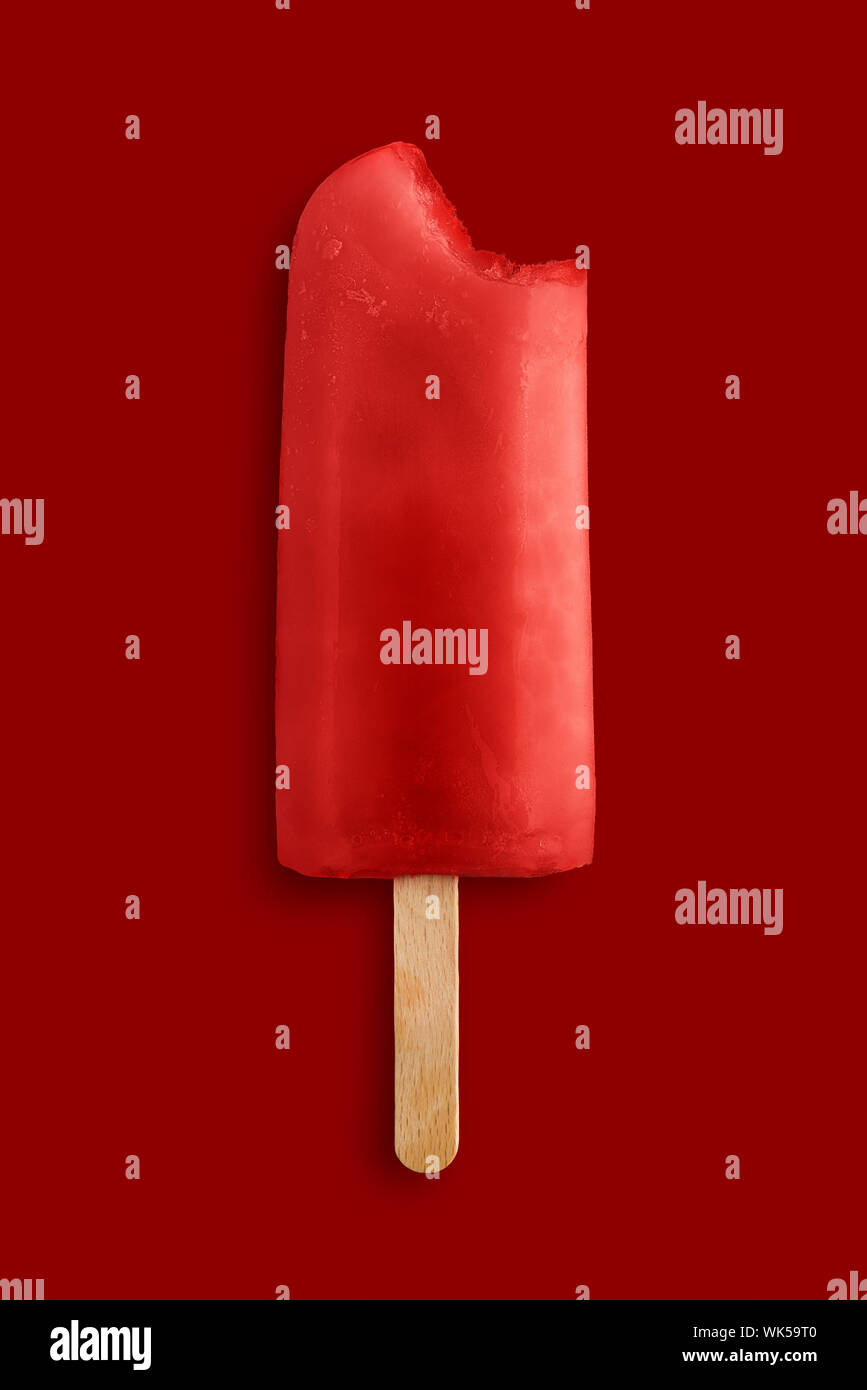 strawberry bitten ice lolly on red background Stock Photo - Alamy