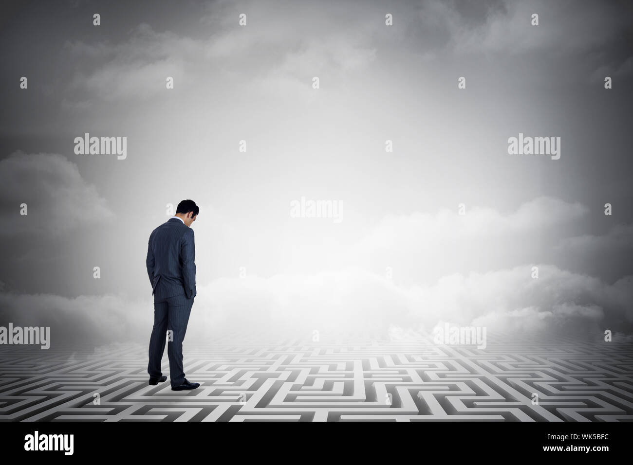 Businessman standing against maze in sky above desert landscape Stock ...