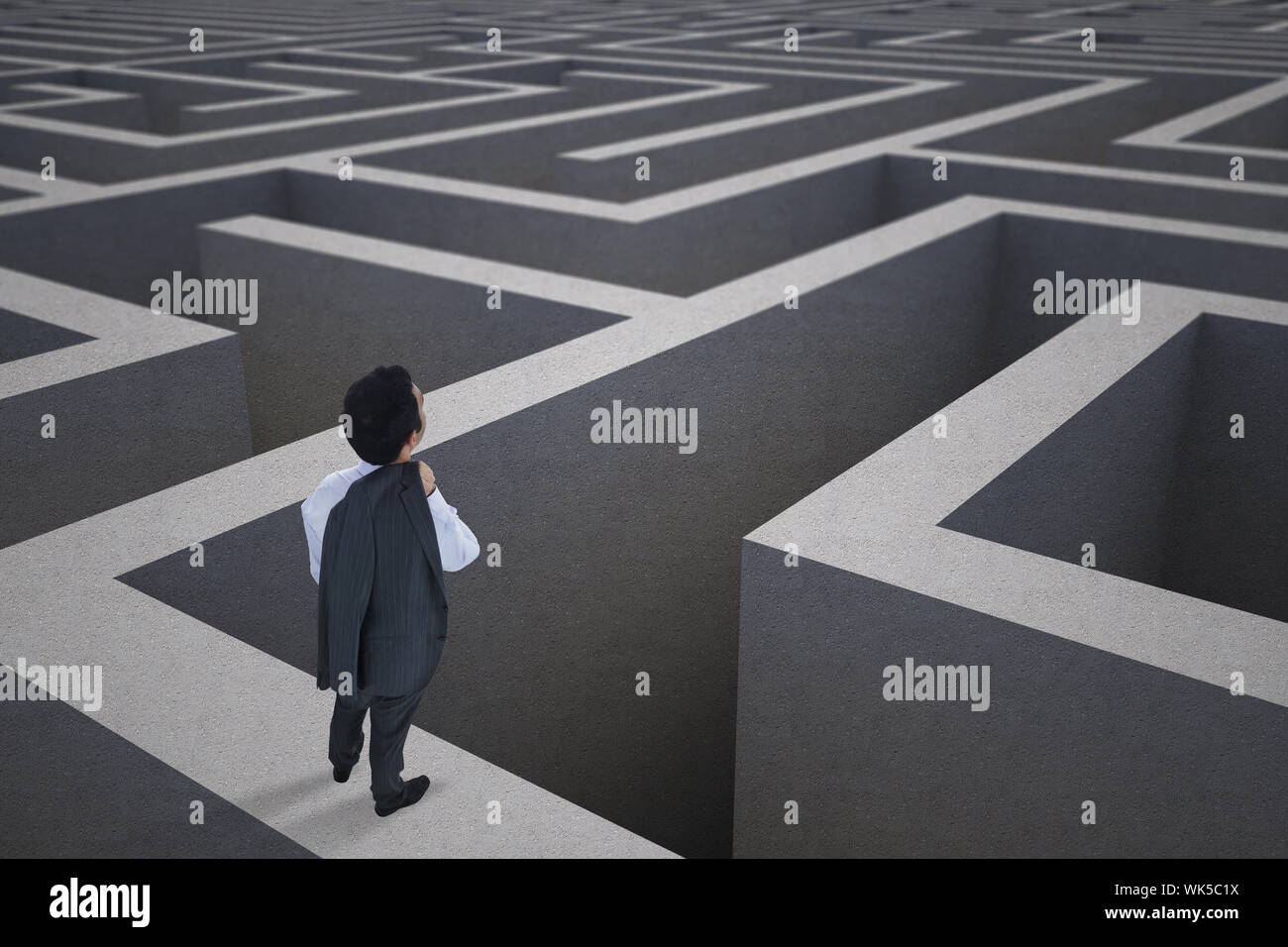 Businessman standing against difficult maze puzzle Stock Photo - Alamy