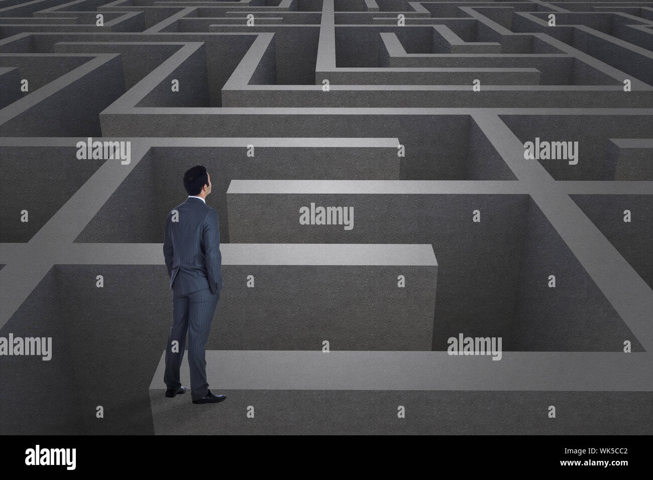 Businessman standing against difficult maze puzzle Stock Photo - Alamy
