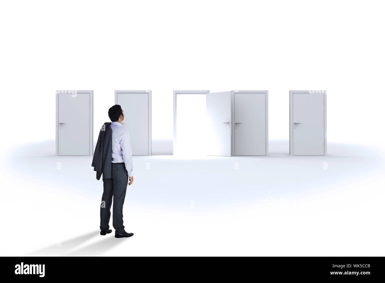 Businessman standing against door revealing bright light Stock Photo ...