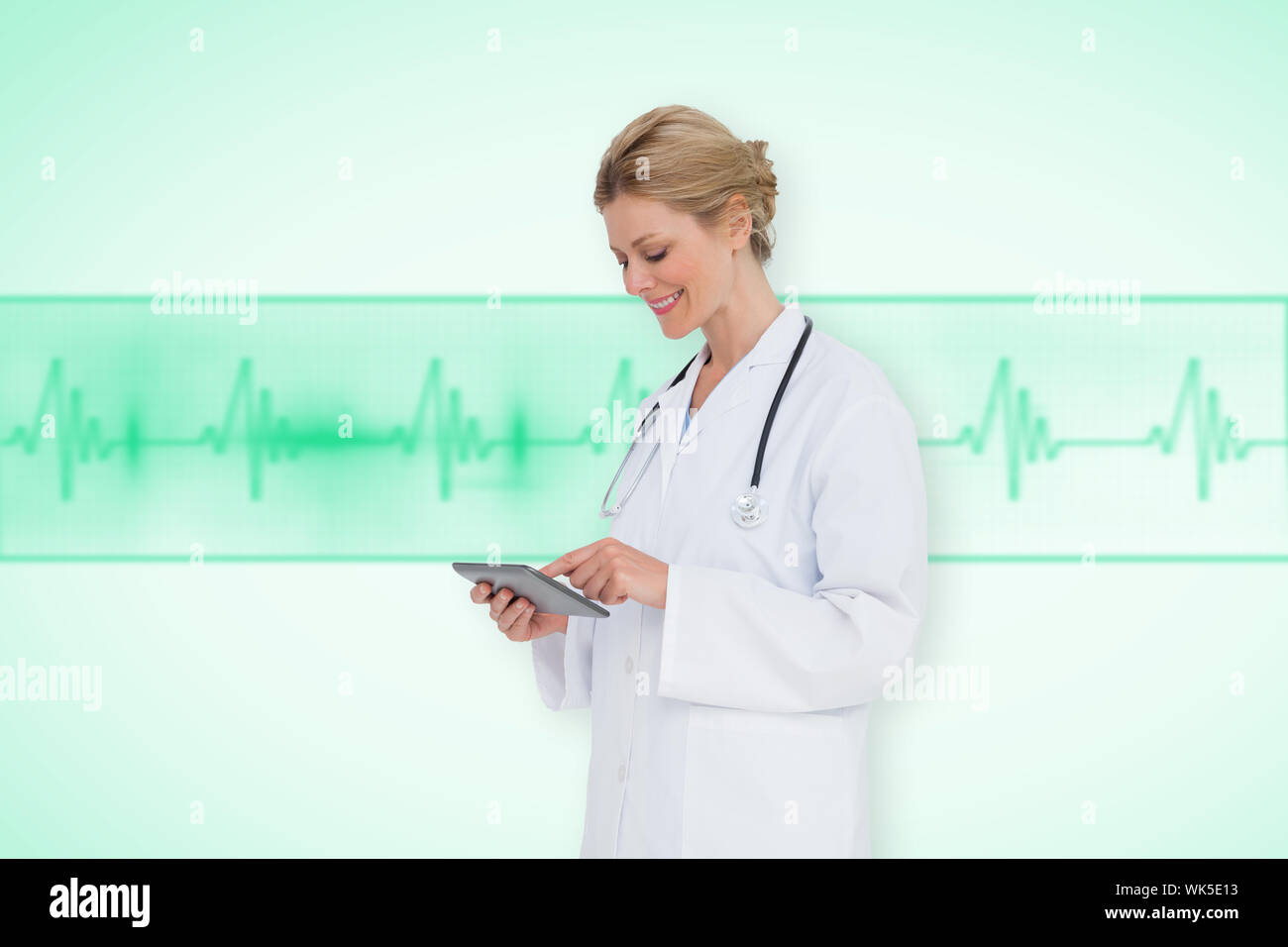 Blonde doctor using tablet pc against green medical background with ecg ...