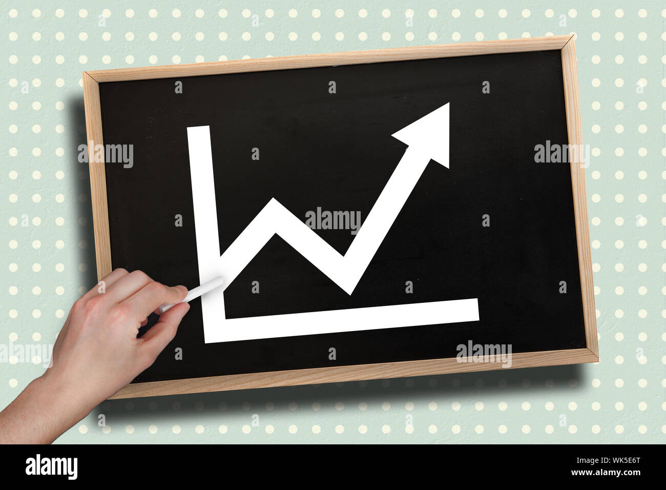 Composite image of hand drawing graph with chalk on chalkboard with ...