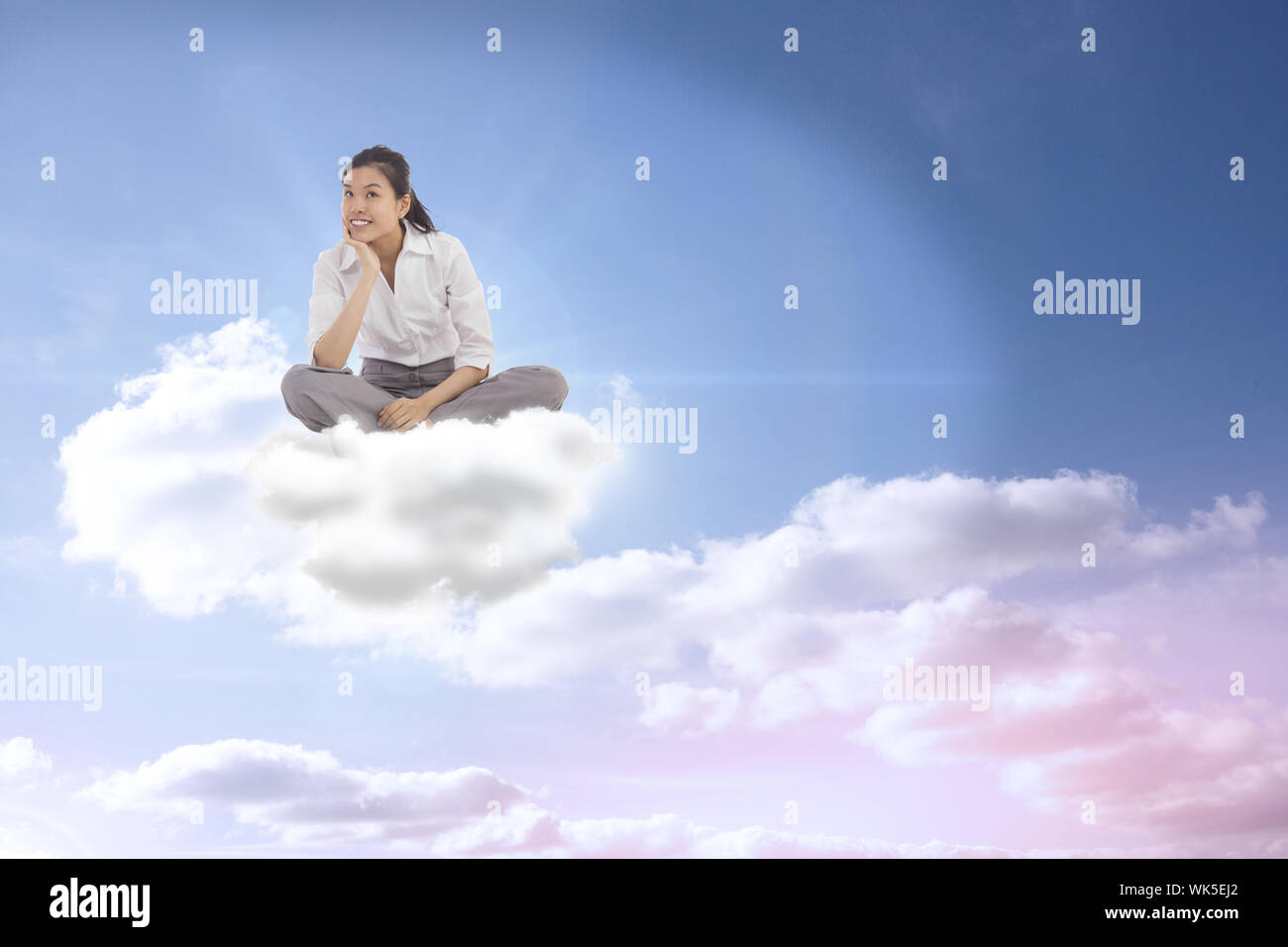 Businesswoman sitting cross legged thinking against beautiful blue ...
