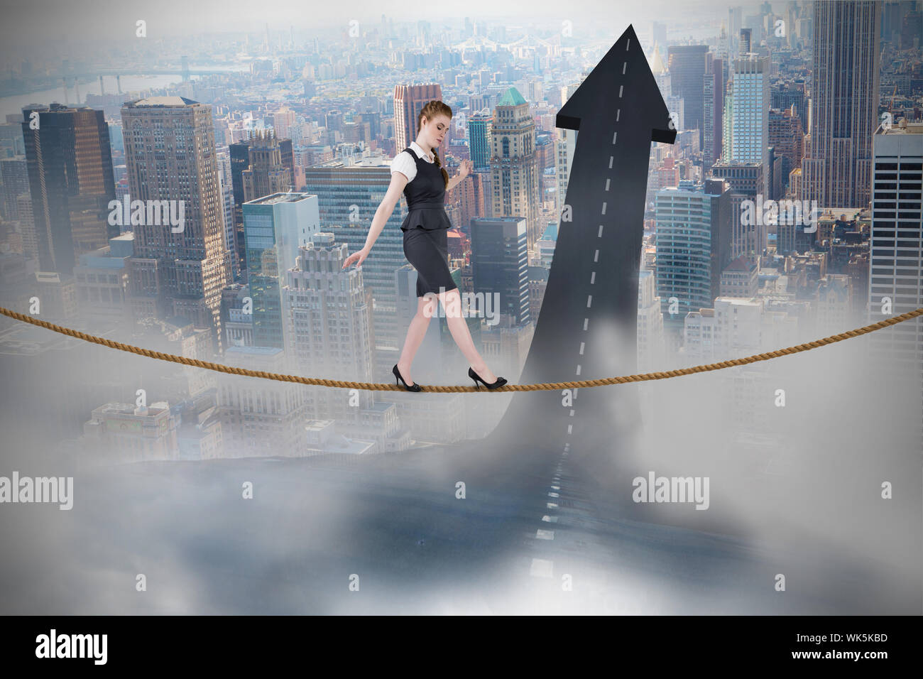 Businesswoman doing a balancing act against road turning into arrow ...