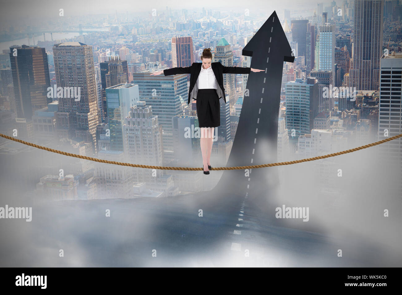 Businesswoman performing a balancing act against road turning into ...