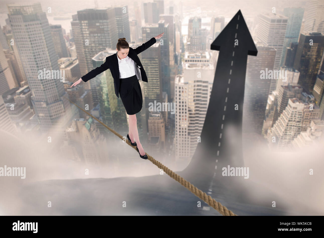 Businesswoman performing a balancing act against road turning into ...