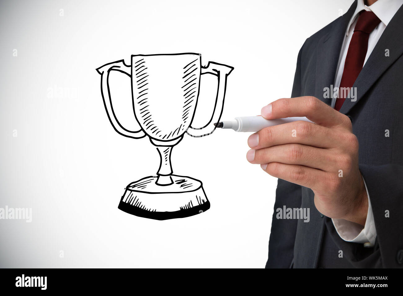Composite image of businessman drawing winners cup white background ...