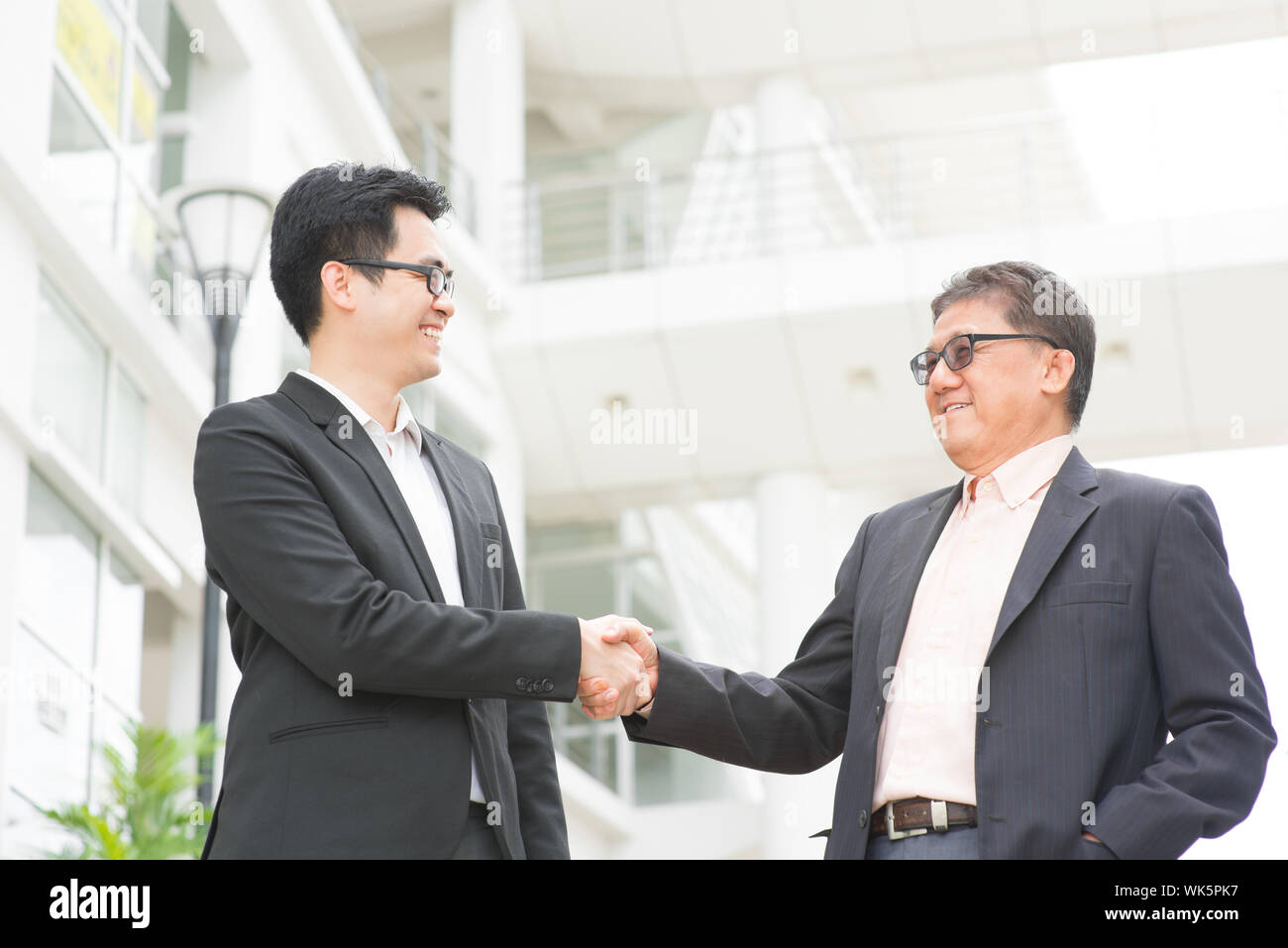 Asian businessmen handshaking. Senior CEO hand shake with young ...