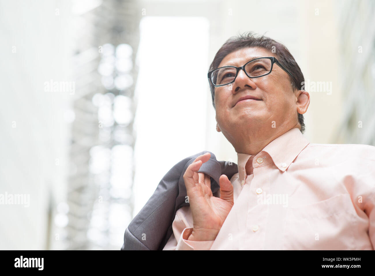 Portrait of 60s Asian Chinese CEO boss smiling and looking away. Senior ...