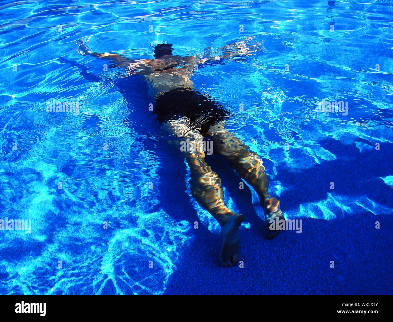 Man enjoying a cool refreshing summer dip in beautiful blue waters of a ...