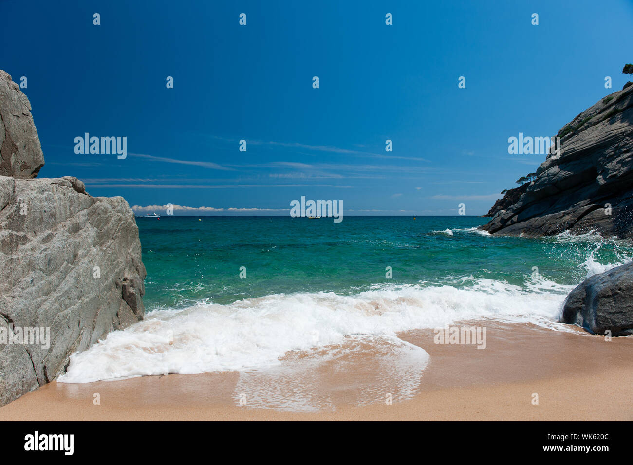 Lonely beach with waves and boats at the horizon Stock Photo - Alamy