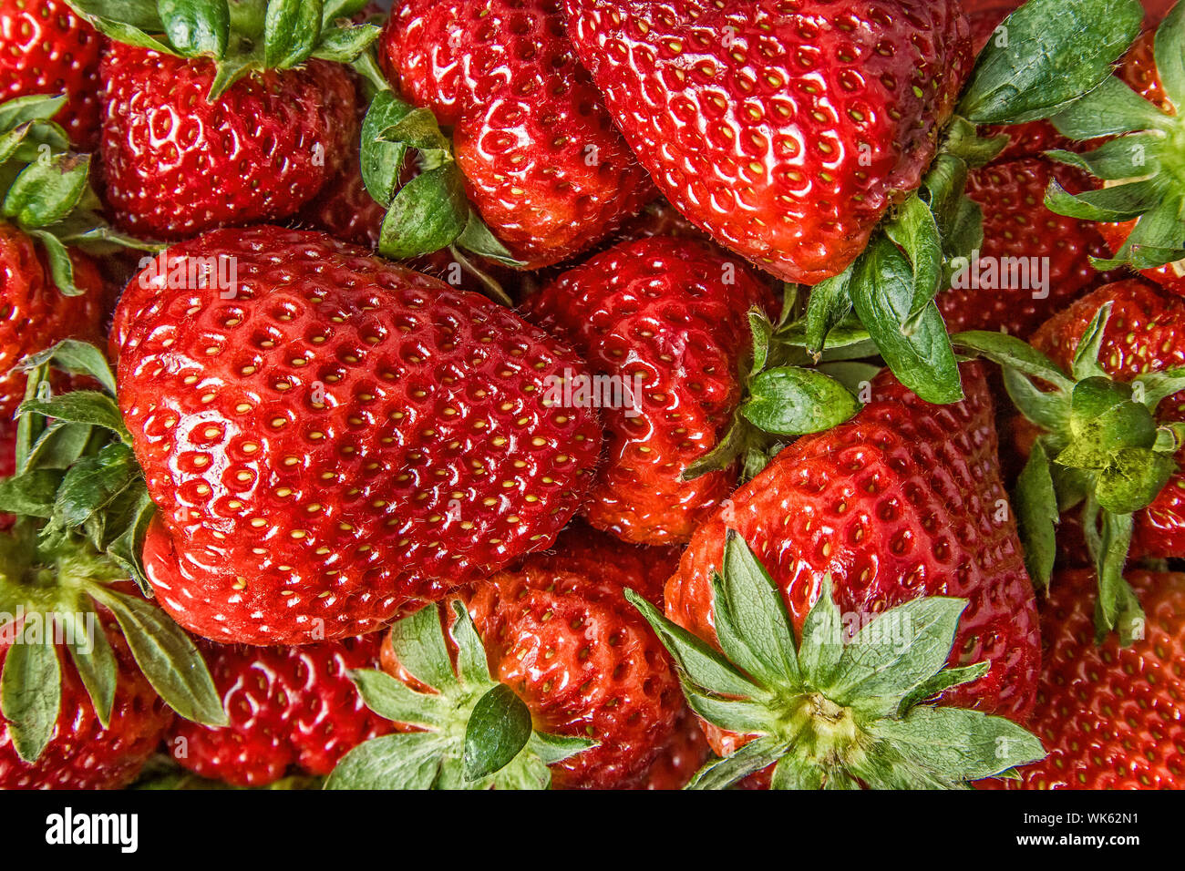 Pile of beautiful strawberries on a pile background Stock Photo - Alamy