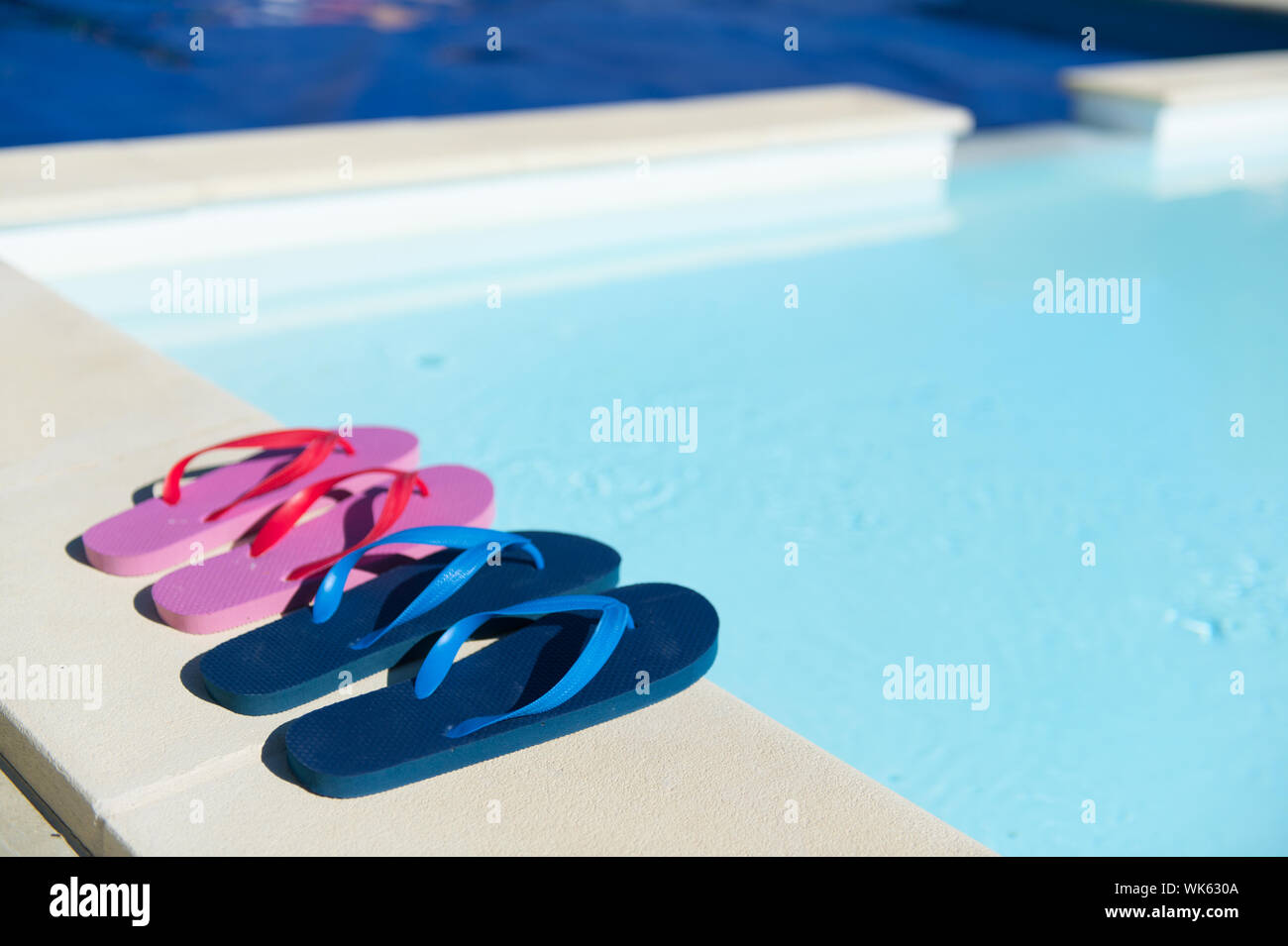 Flip flops for him and her at the swimming pool Stock Photo - Alamy