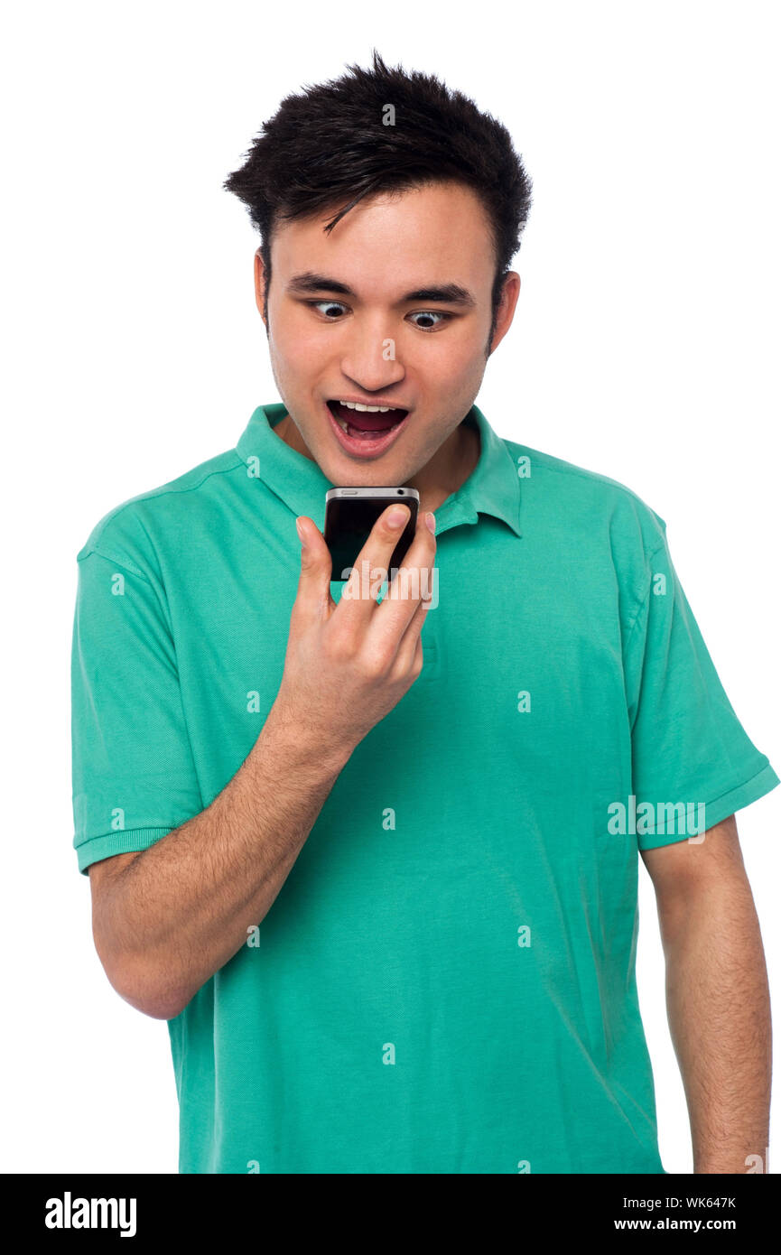 Excited young man looking his cellphone Stock Photo - Alamy