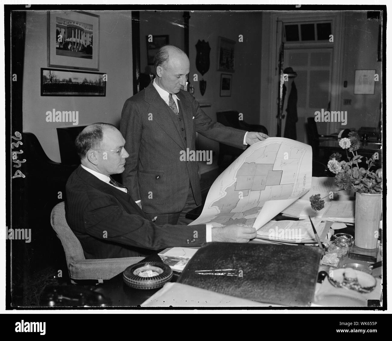 J. Frank Wilson, seated, Chief of USSS, looking over a law enforcement ...