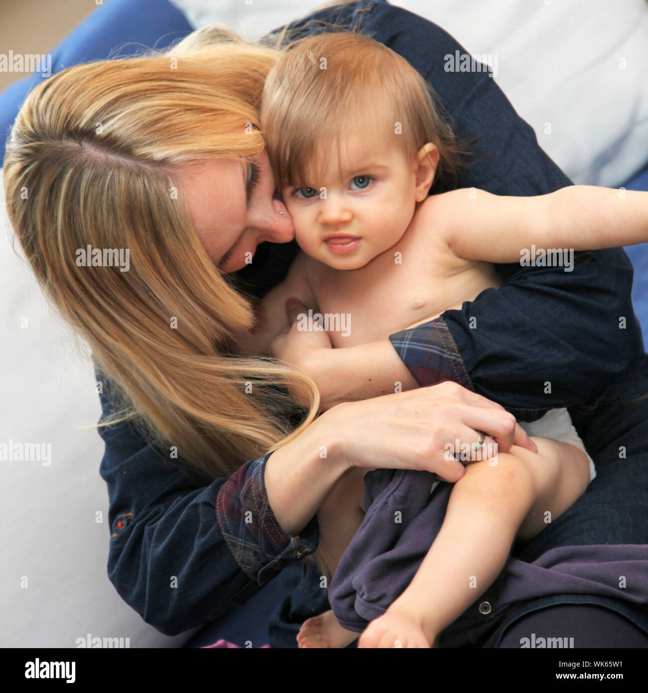 Young mother caressing her baby and holds it lovingly in her arms Stock ...